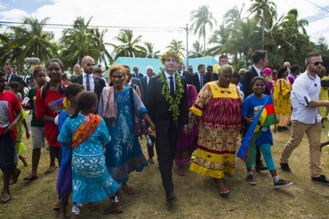 Emmanuel Macron pose avec une couronne de fleurs sur la tête, en visite ...