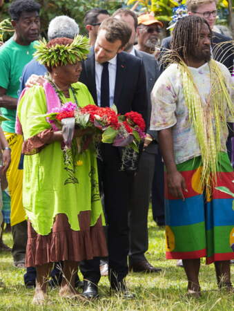 Emmanuel Macron pose avec une couronne de fleurs sur la tête, en visite ...